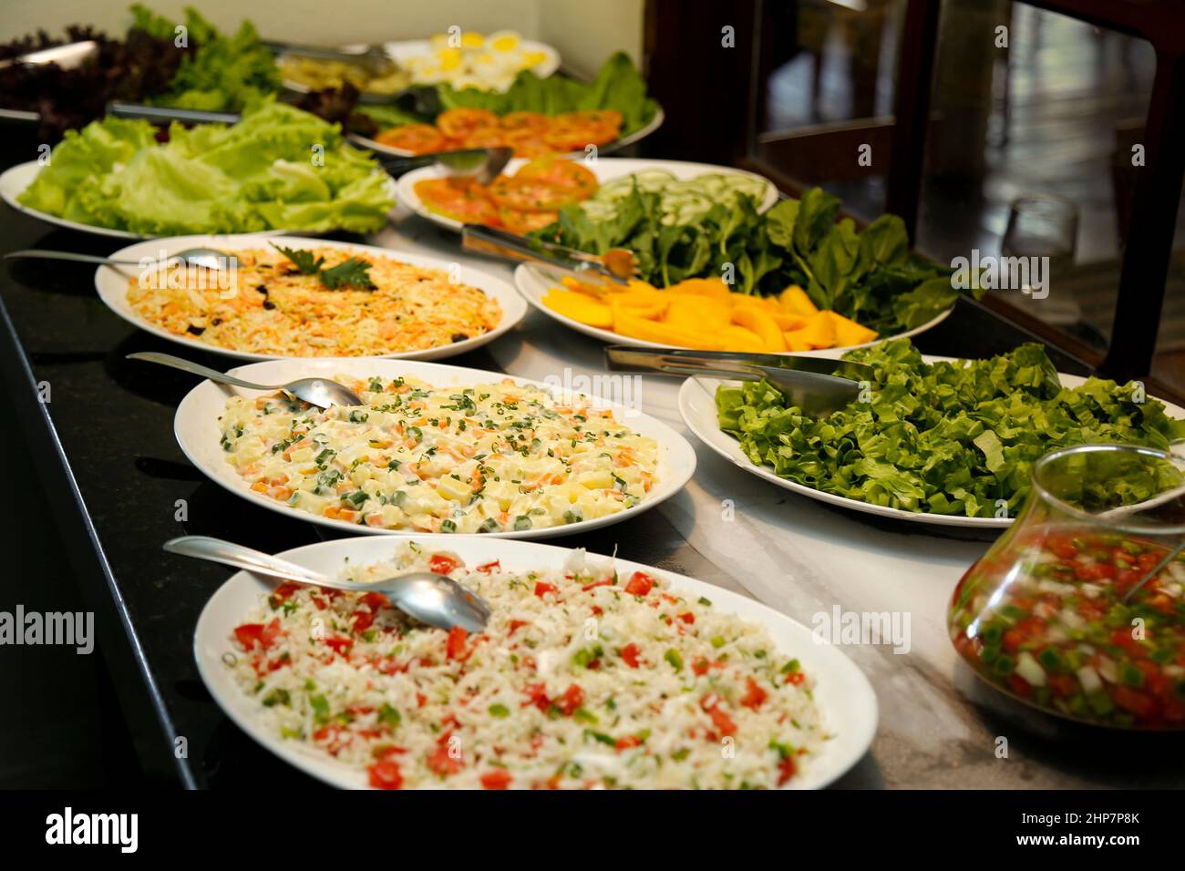 large table with various types of salad ready to serve on the plate ...