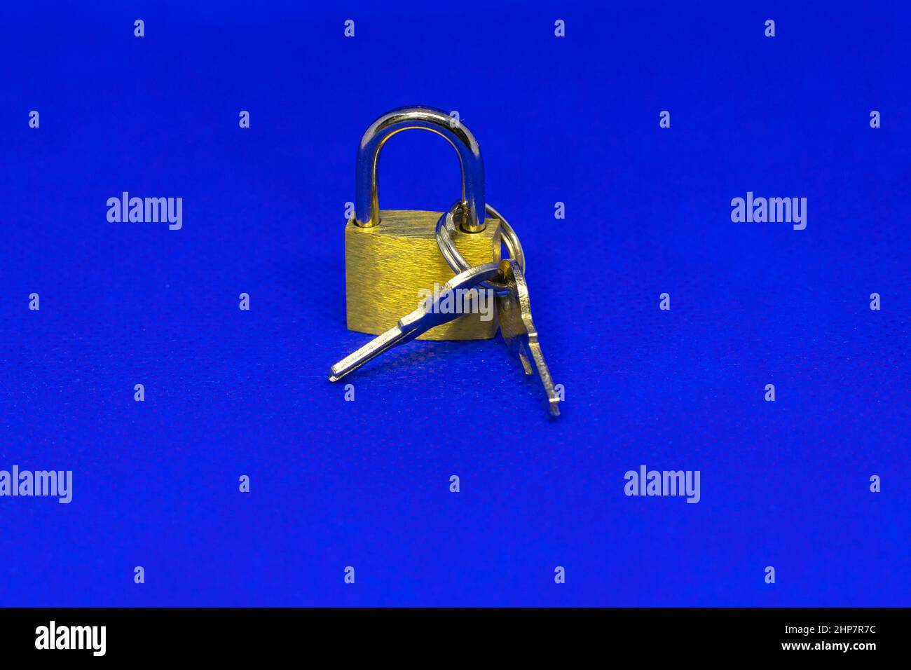 Small padlock with two keys. The photo has a blue background Stock ...