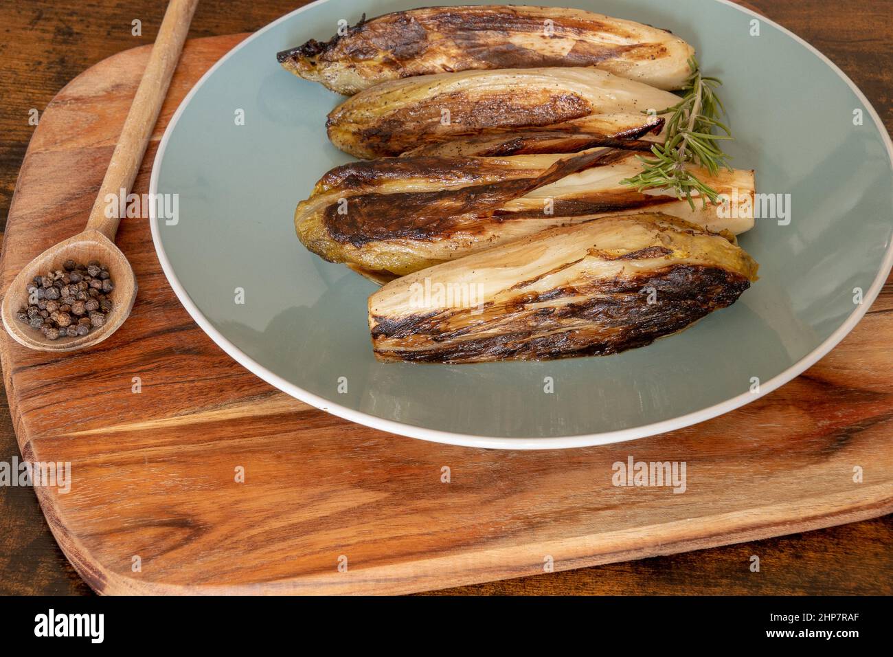 braised endives in a dish on a wooden board Stock Photo - Alamy