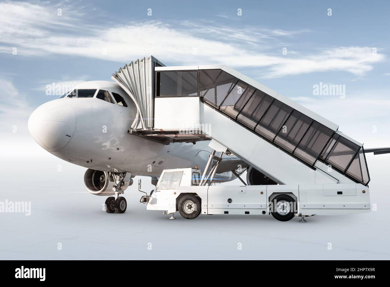 Passenger aircraft with a boarding steps on bright background with sky ...