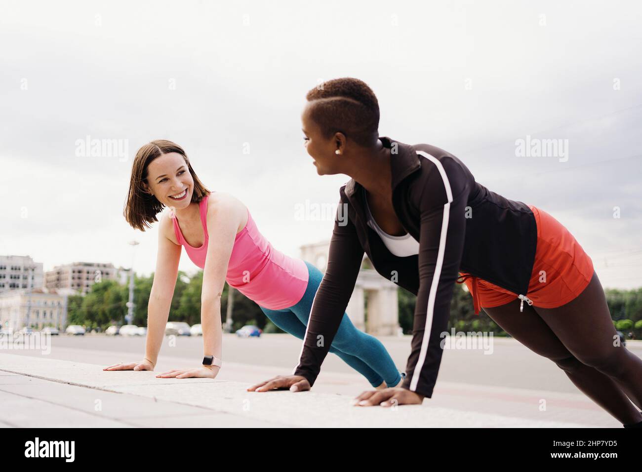 Two smiling diverse young woman in Athletic Workout Clothes are Doing a ...