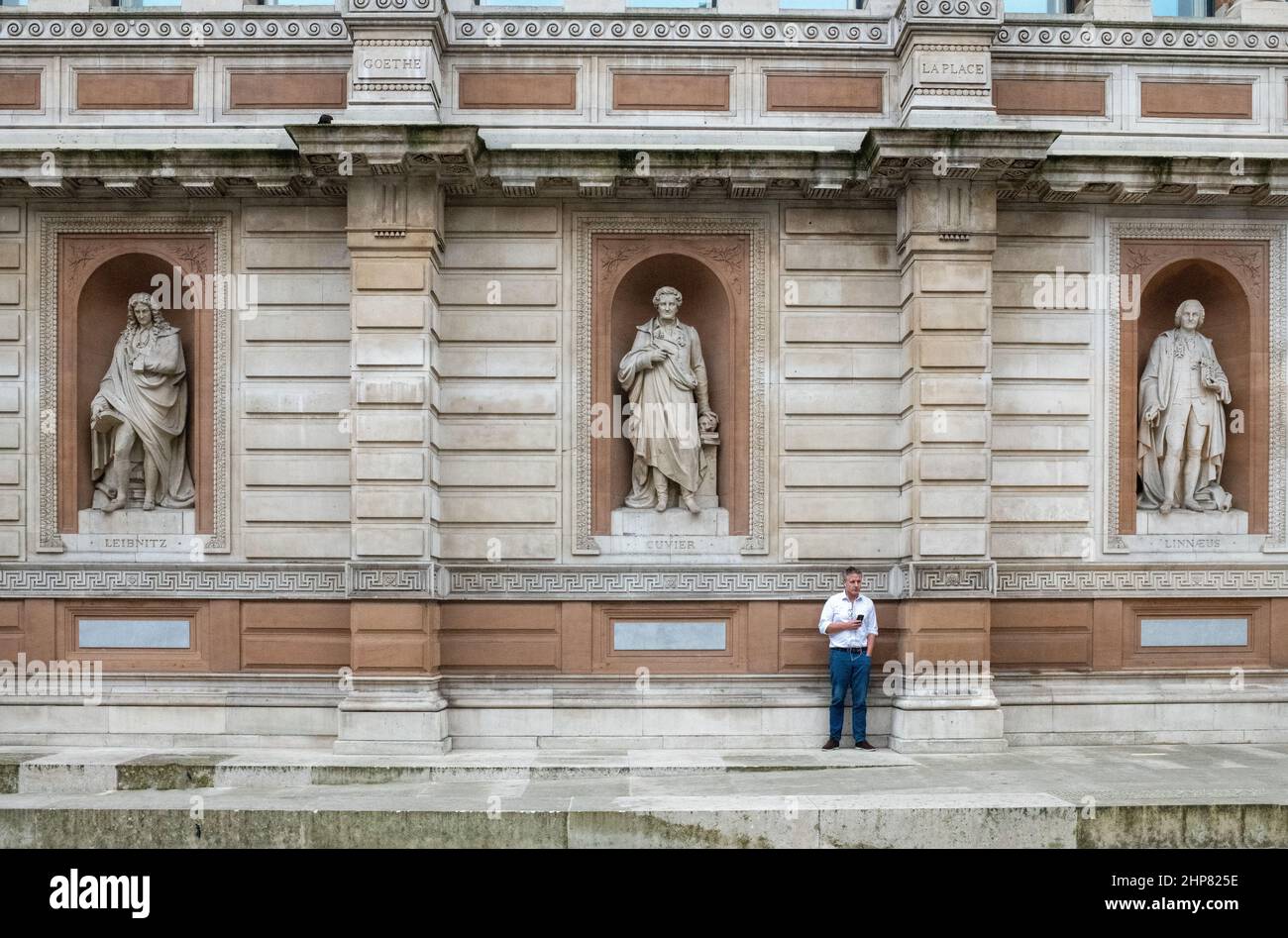Statues at the Royal Academy of the Arts London looking down on a man ...