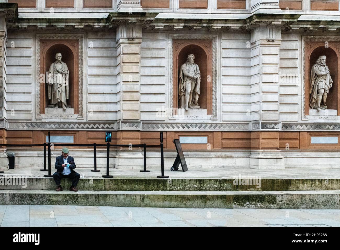Statues at the Royal Academy of the Arts London looking down on a man ...