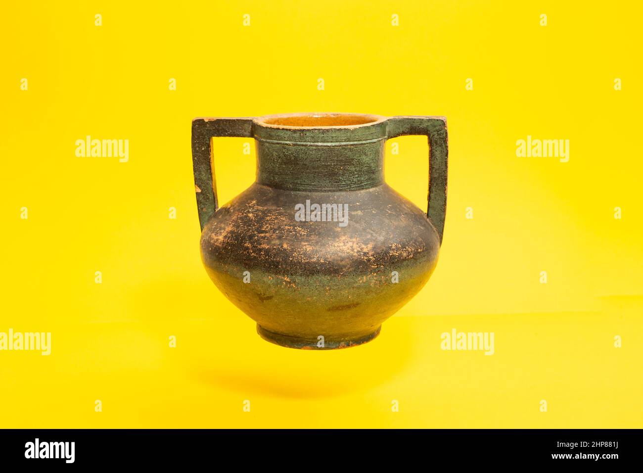 double handled pottery vase levitating on yellow background Stock Photo ...
