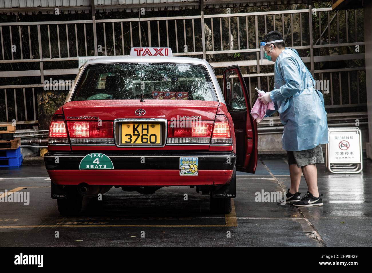 A taxi driver disinfects his vehicle after dropping off patients at a ...