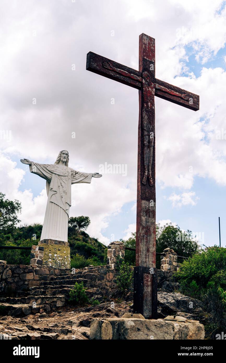 Vertical shot of a big metal cross and Jesus Christ statue on the top ...