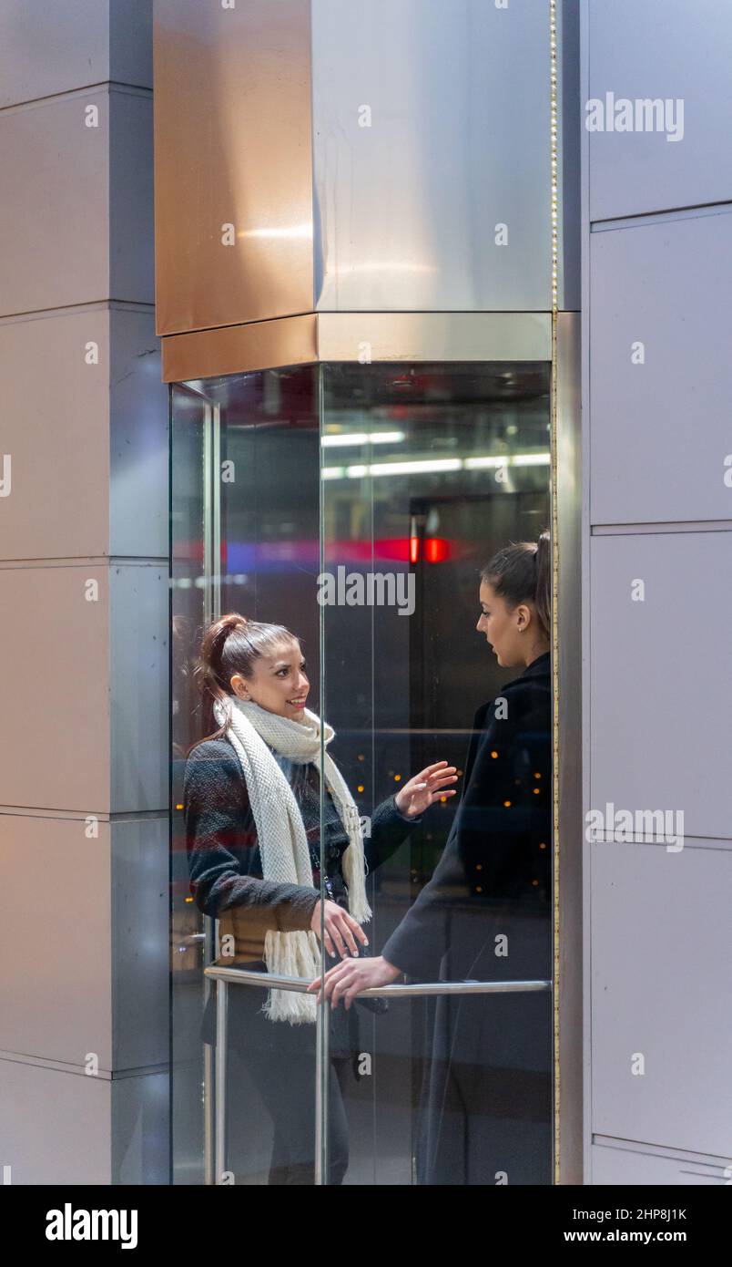 Two attractive and beautiful businesswomen are having a conversation in ...