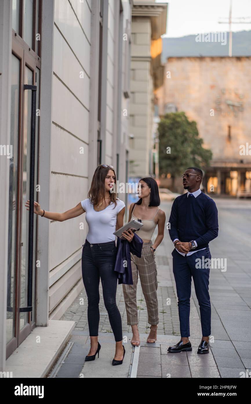Three multiracial and young co workers are going towards the company ...