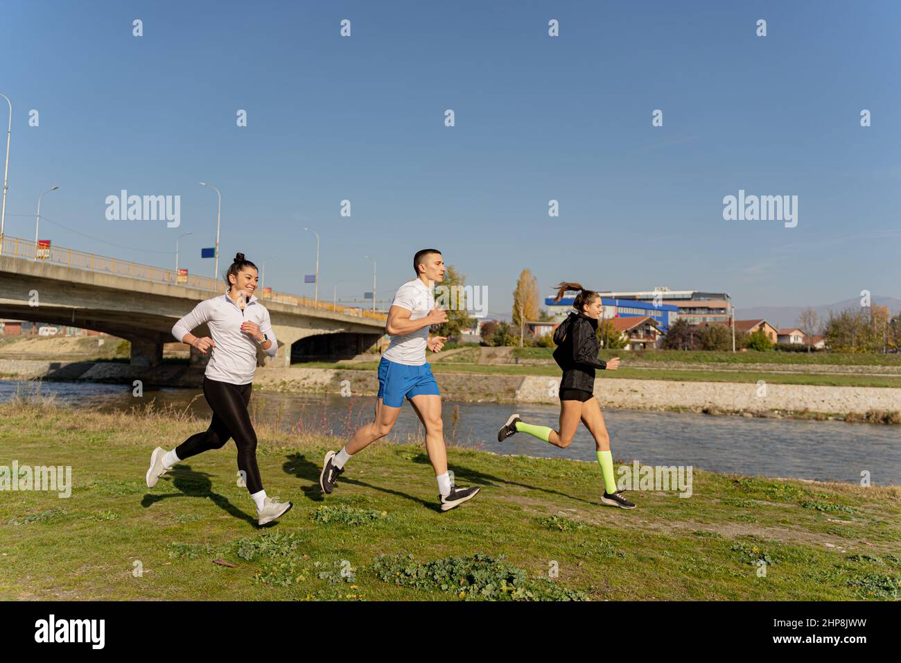 Three amazing and fit friends are smiling and running together Stock ...