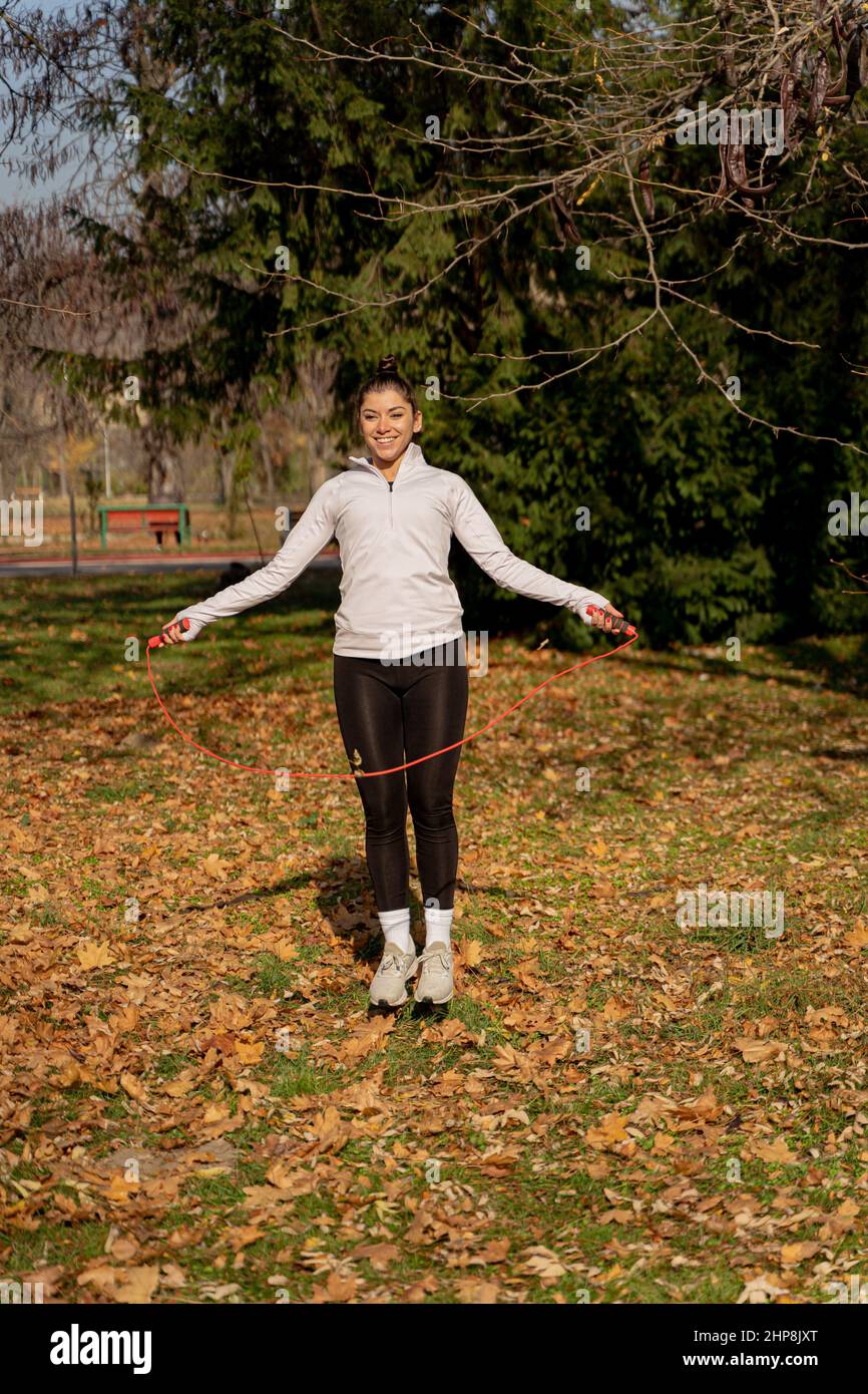 Attractive and beautiful fit girl is jumping on rope outside Stock ...