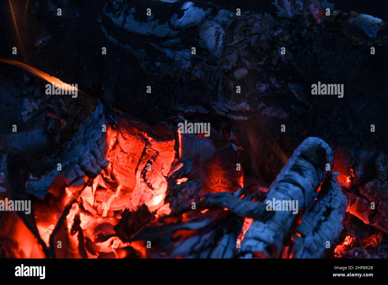 Smoldered logs burned in vivid fire close up. Atmospheric background ...