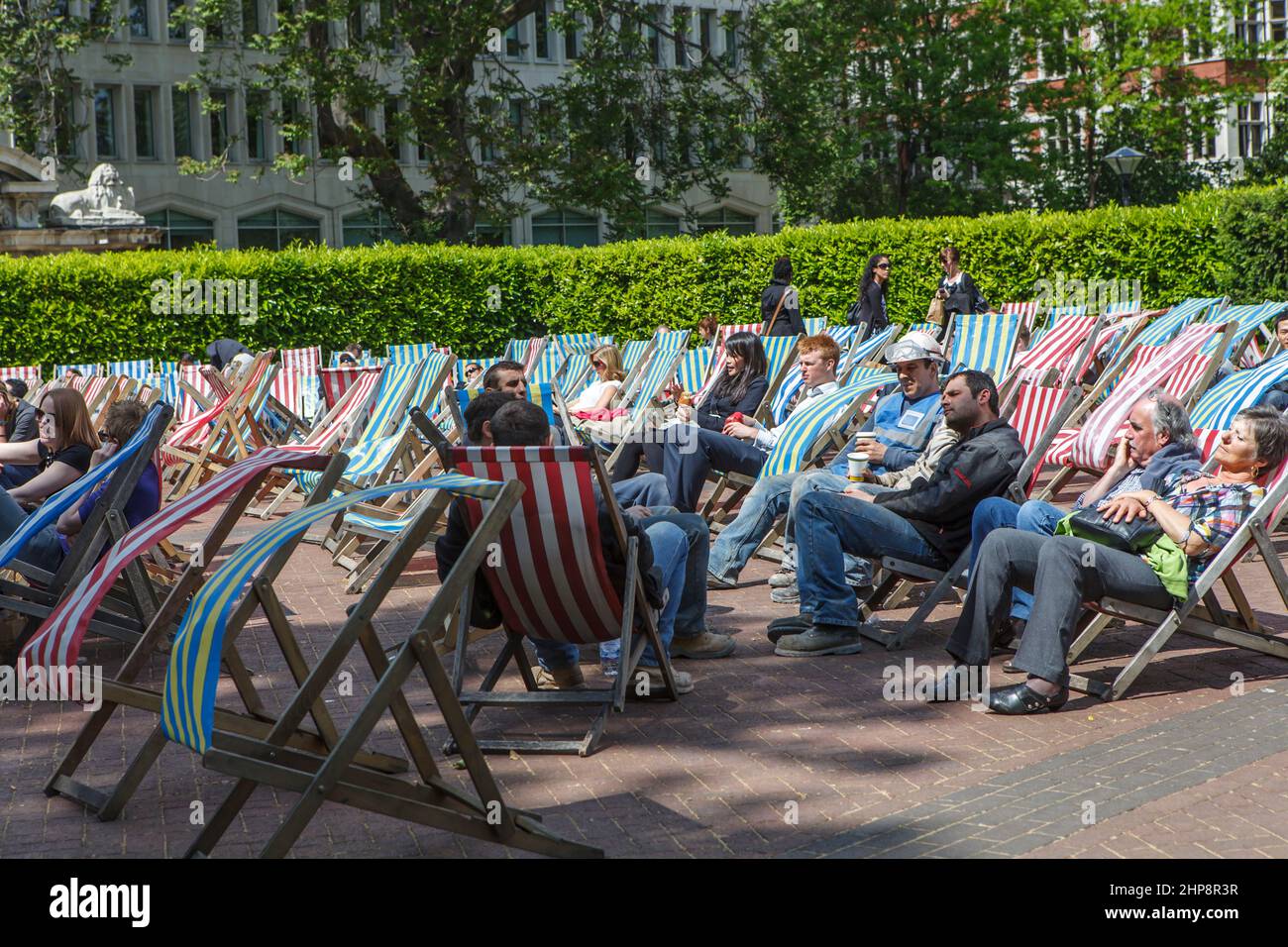 London, UK - 20 September 2021, People relax in sun loungers in front ...
