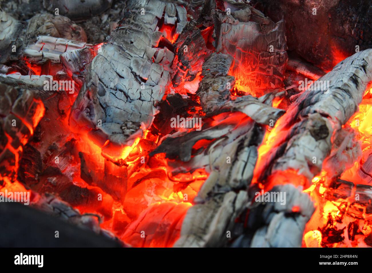 Smoldered logs burned in vivid fire close up. Atmospheric background ...
