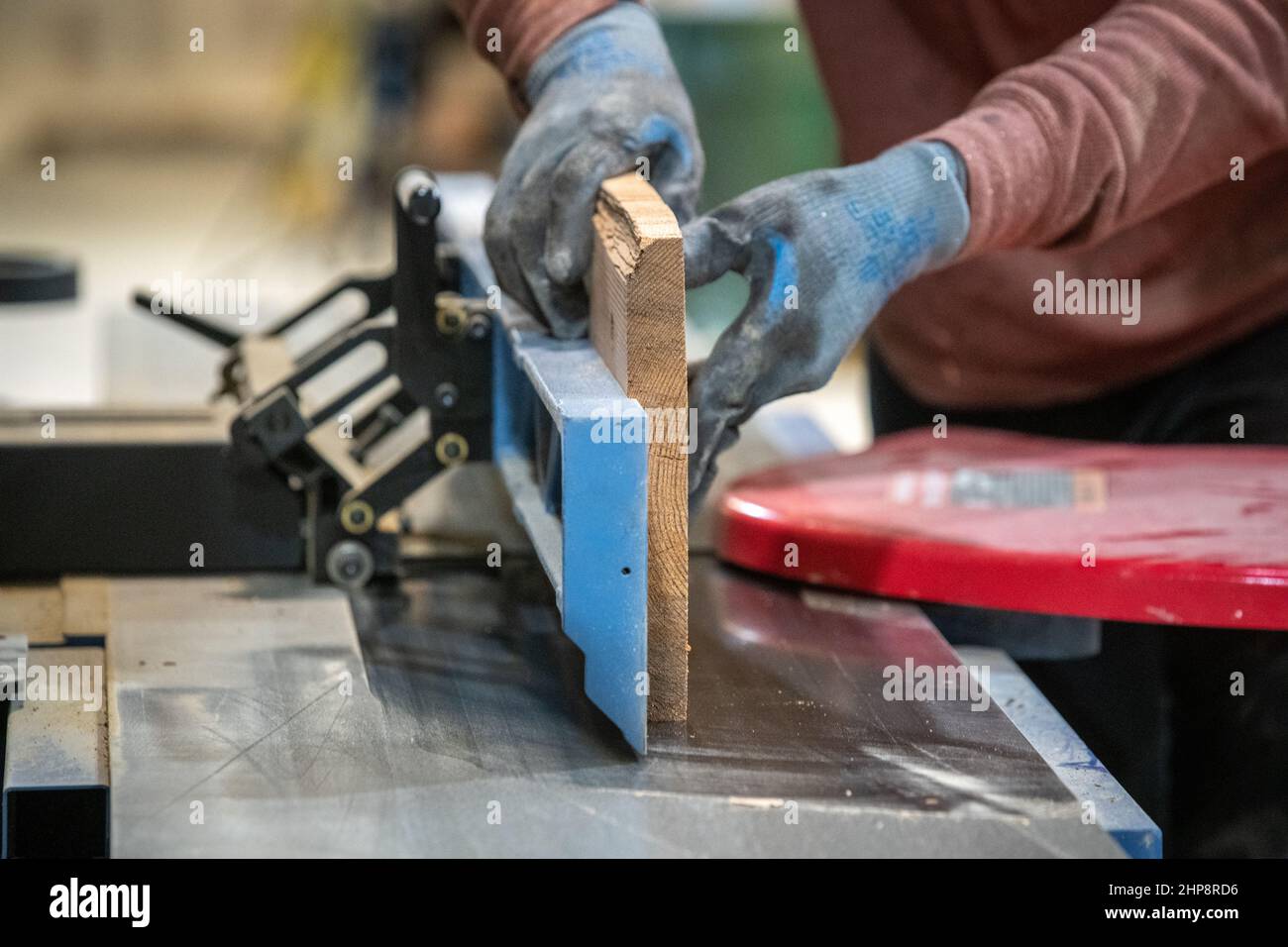 Man cutting pieces of lumber with table saw in wood shop Stock Photo ...