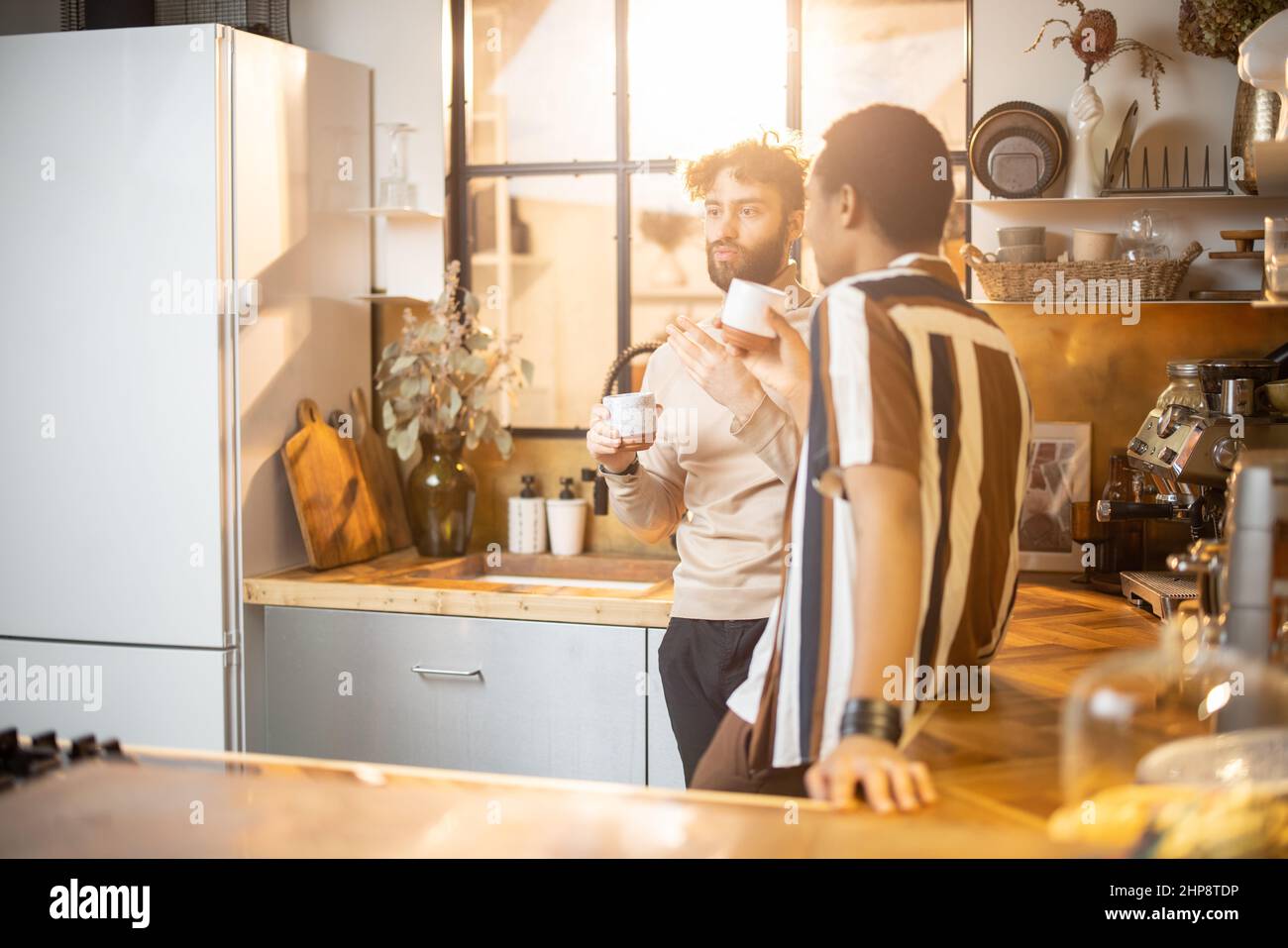 Two men talking and drinking coffee on kitchen at home Stock Photo - Alamy
