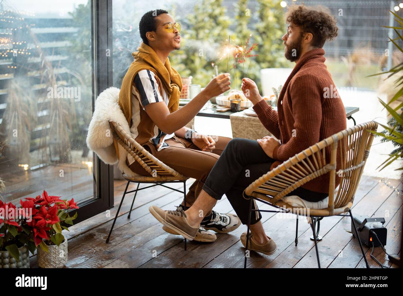 Two male friends celebrating with sparklers at backyard Stock Photo - Alamy