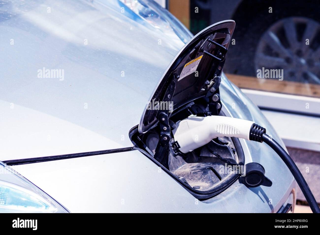 Close up of the power supply plugged into an electric car.Close up ...