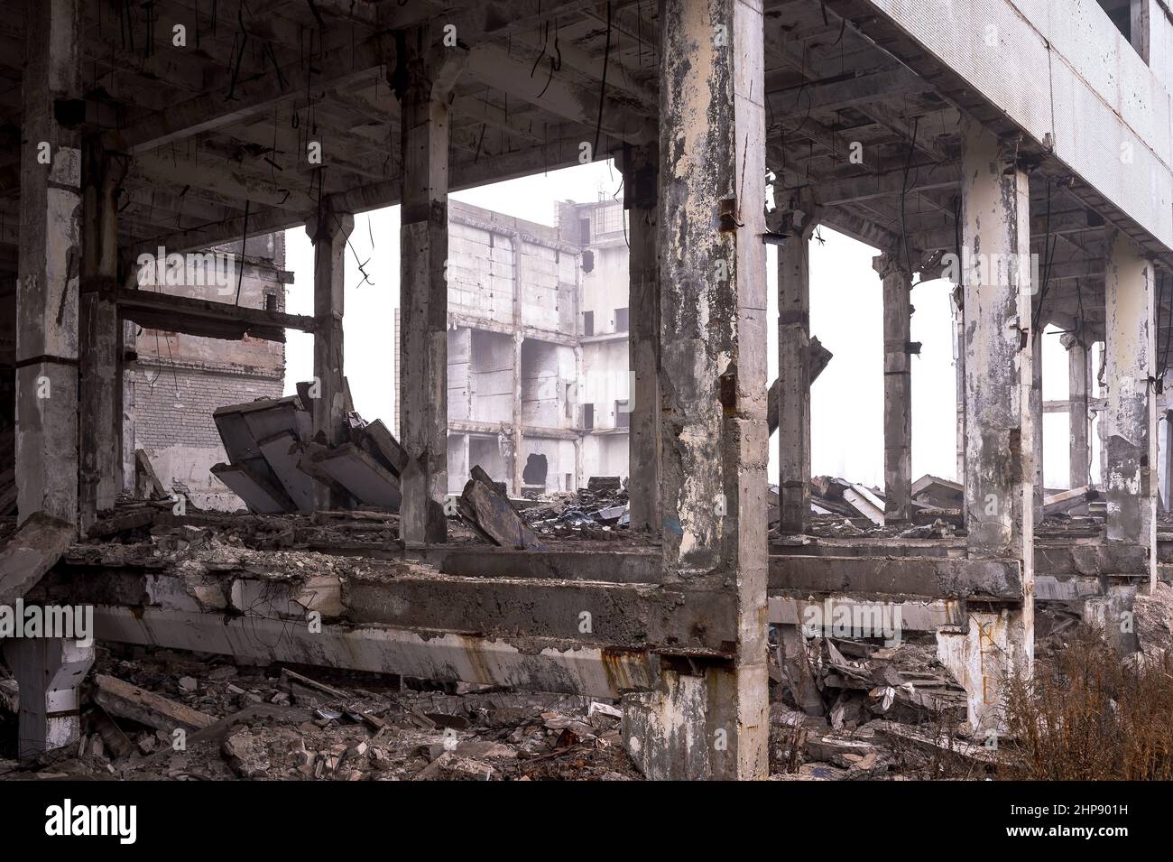The frame of a large destroyed building with piles of gray concrete ...