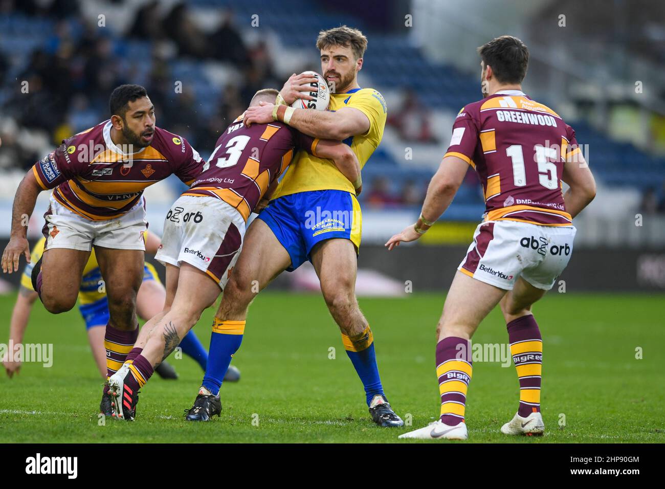 Tom Garratt #26 of Hull KR is tackled by Luke Yates #13 of Huddersfield ...
