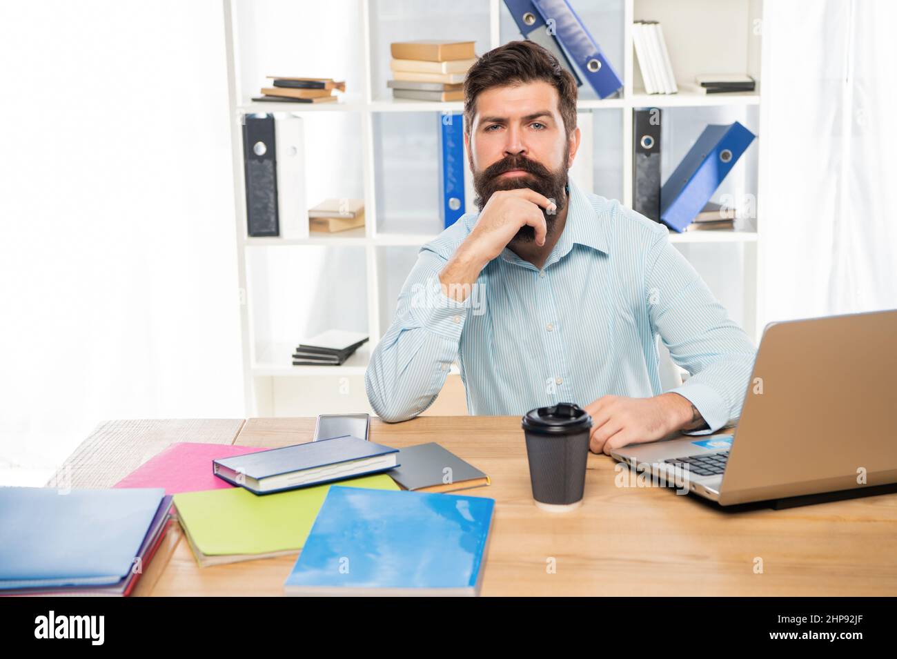 Serious manager thinking sitting at office desk at workplace Stock ...