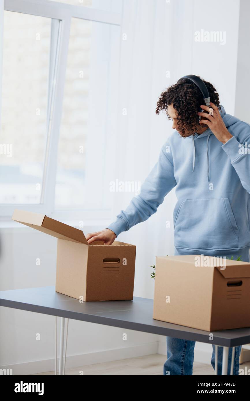 handsome guy cardboard boxes in the room unpacking sorting things out ...
