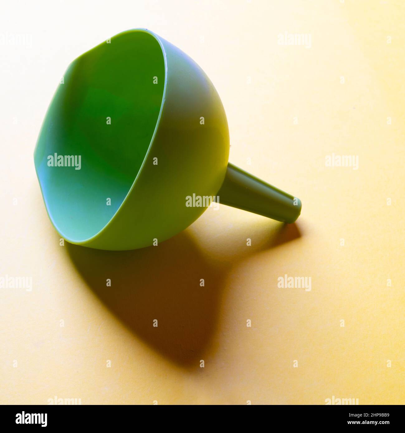 a green plastic funnel on a colored surface Stock Photo - Alamy