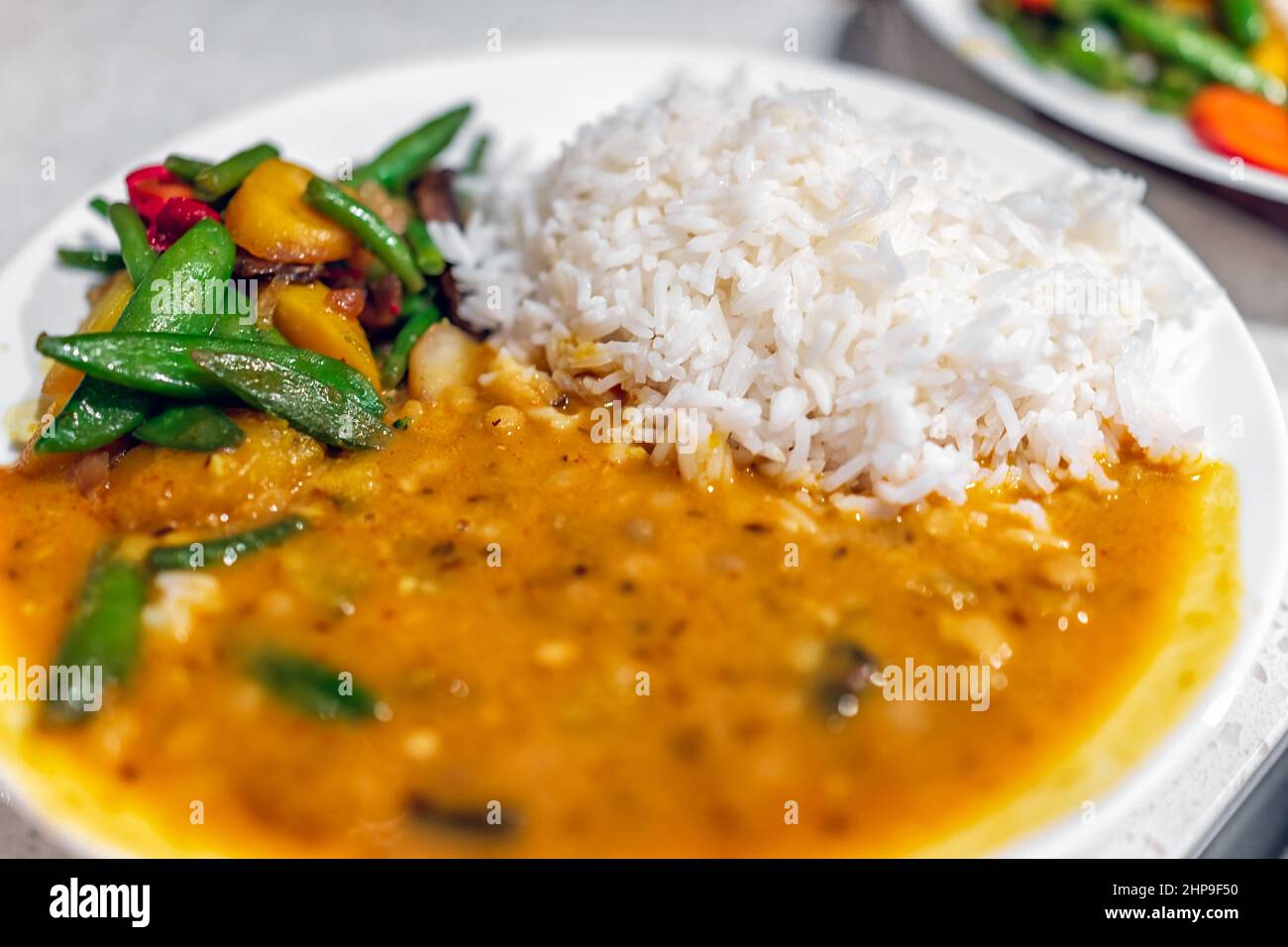 Macro closeup of orange curry healthy coconut squash dal Indian yellow ...