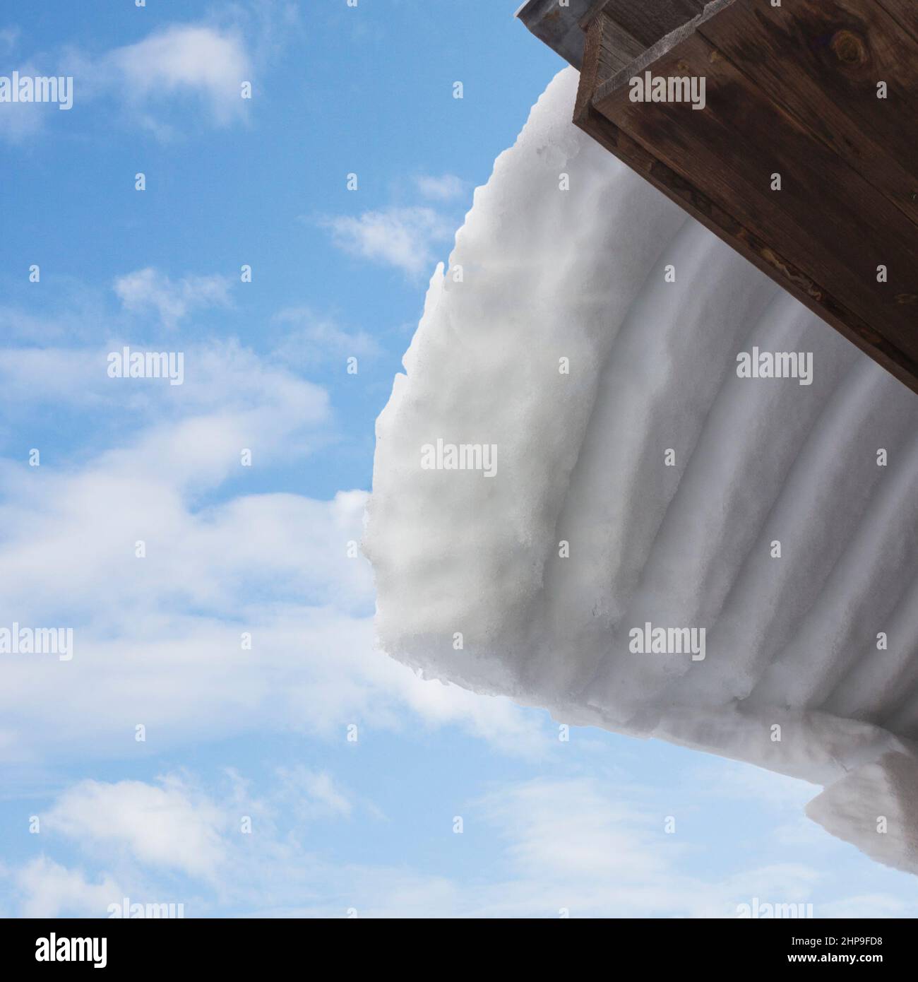 Snowdrift slides off the roof as a result of a thaw. Place of increased ...
