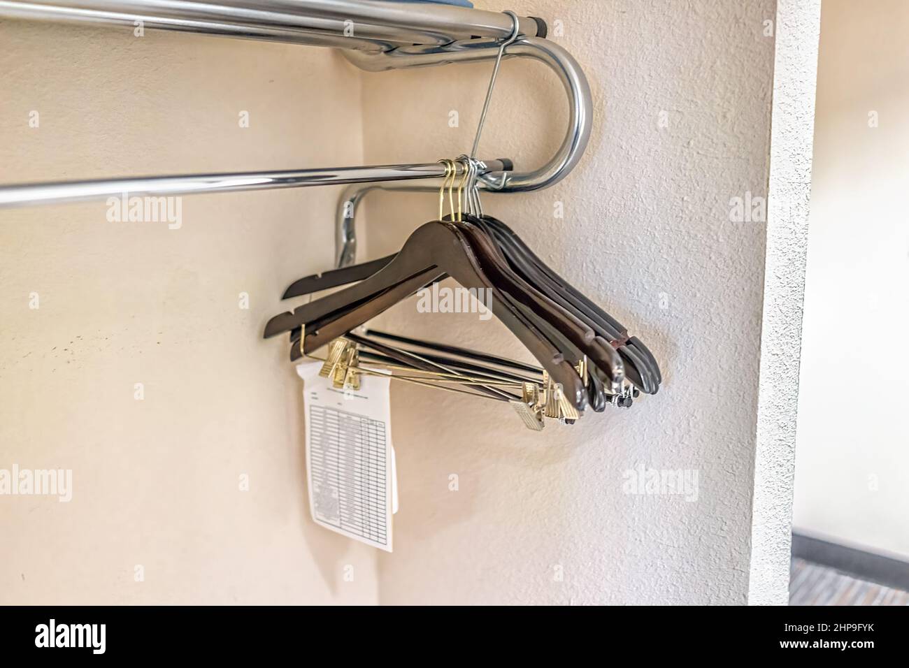 Closeup of closet hangers in empty room on pole stand in modern hotel ...