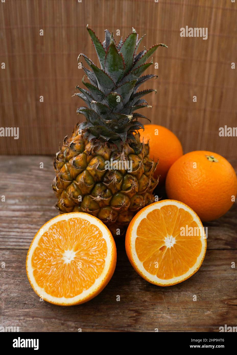 Pineapple and oranges. Tropical fruit on wooden table background ...
