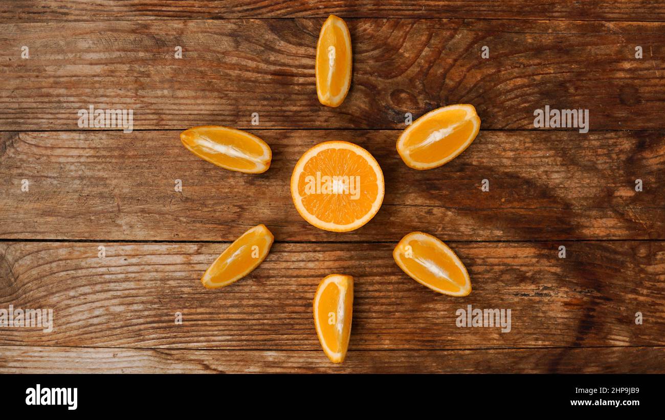 Citrus composition, orange in the shape of sun on the wooden background ...