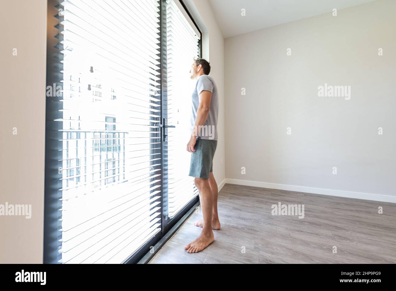 Empty living room interior with young man person standing by balcony ...
