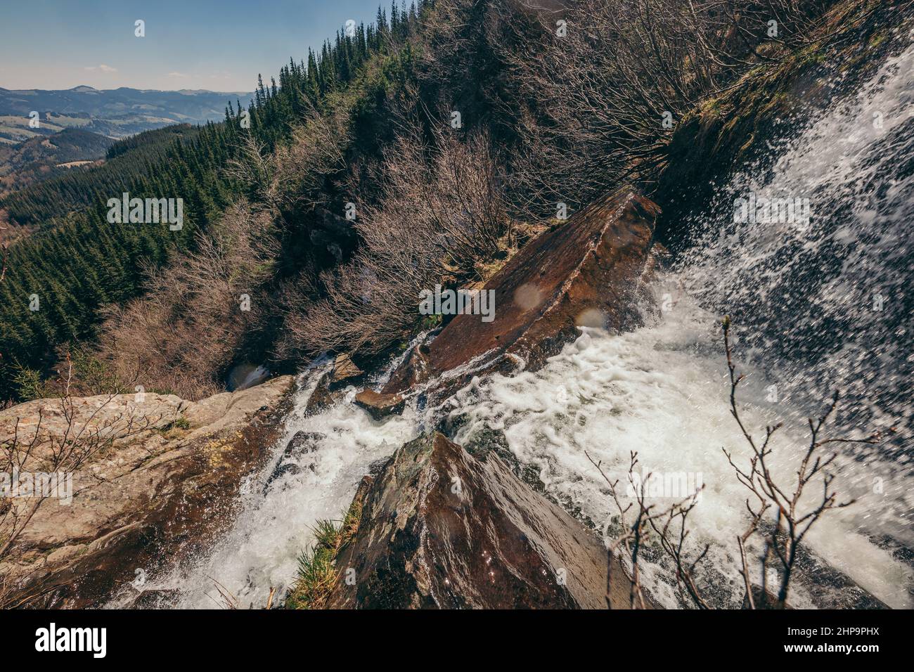 A waterfall with trees on the side of a mountain Stock Photo - Alamy