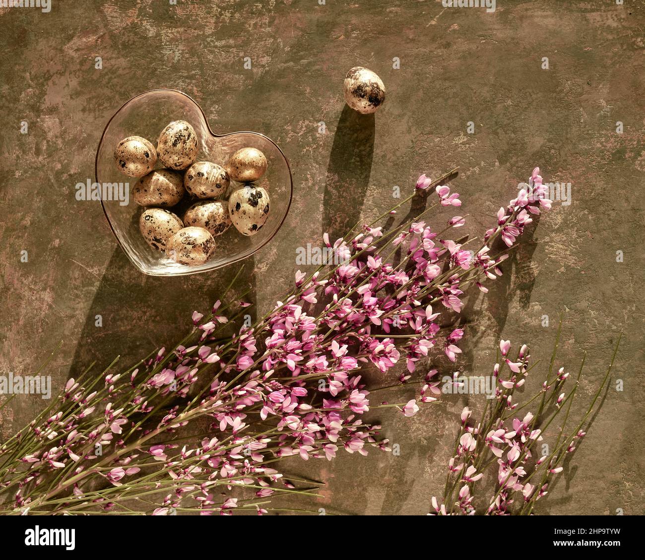 Spring Easter background with pink flowers, golden quail eggs in heart ...