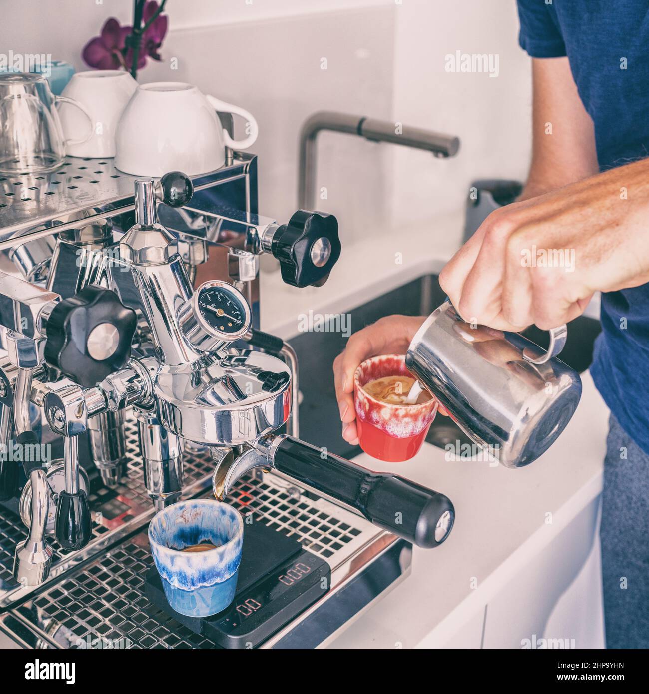 Making making coffee at home with espresso machine pouring steamed milk ...
