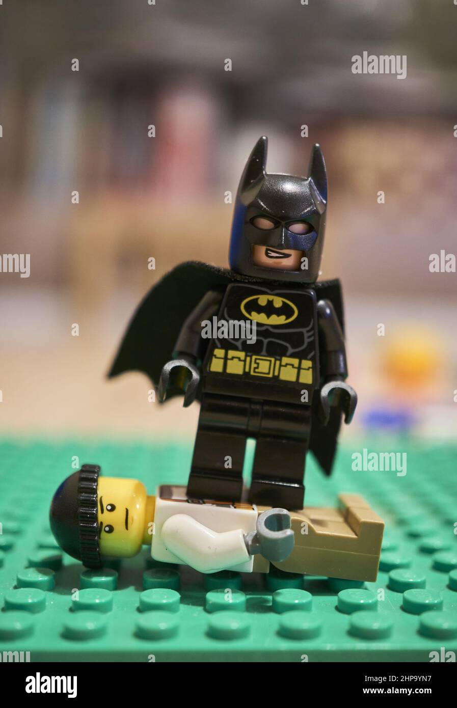 Vertical shot of a Batman Lego figure standing on a prisoner figure ...