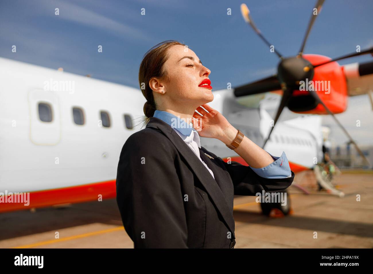 Young woman airline worker standing outdoors at airfield Stock Photo ...