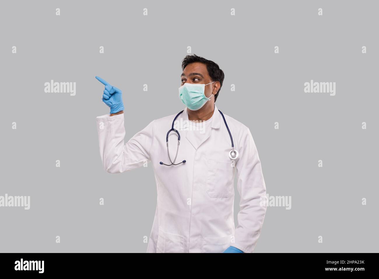 Indian Man Doctor Pointing to Side and Watching to Side Wearing Medical ...