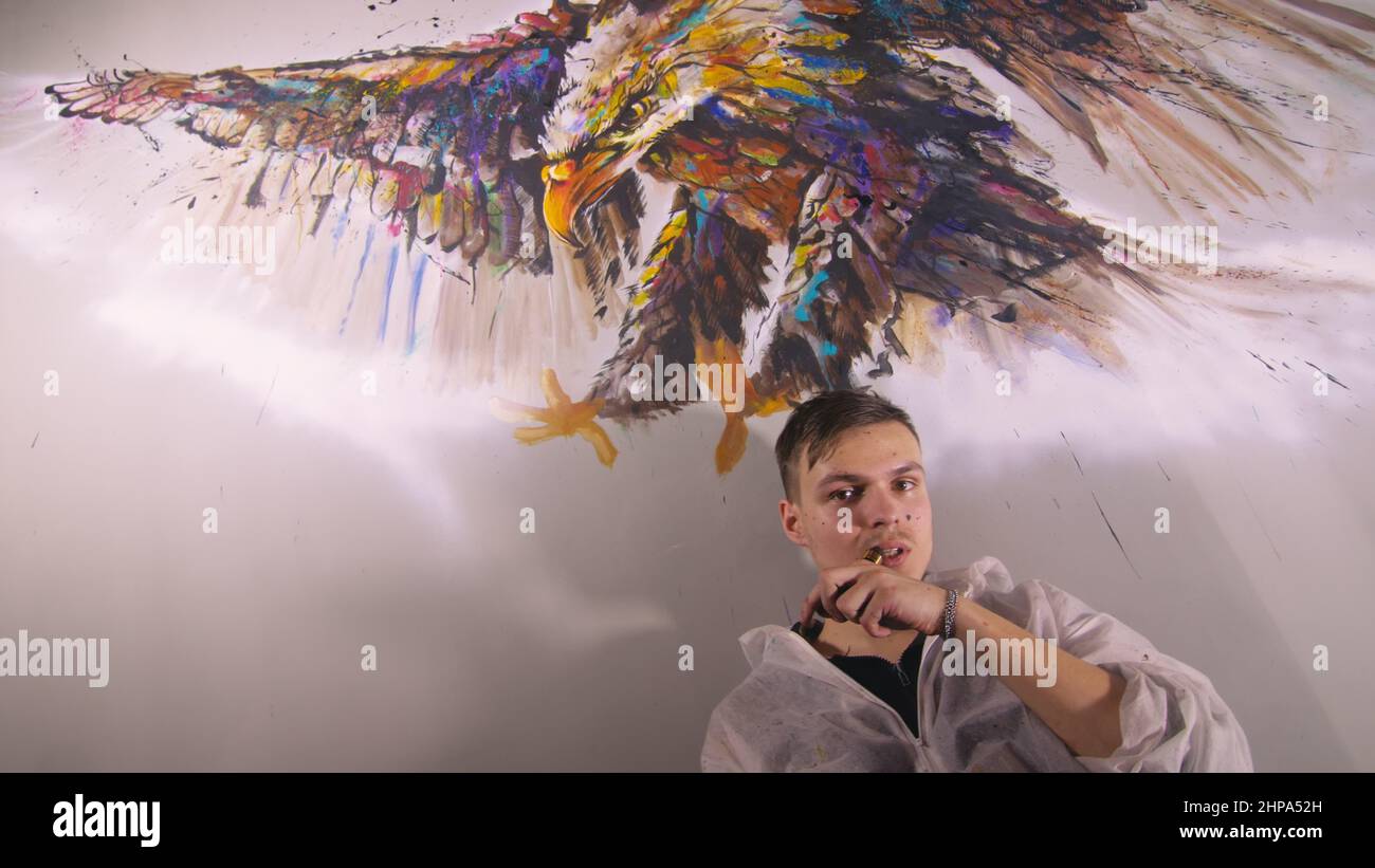 Artist designer draws an eagle on the wall. Craftsman decorator paints ...
