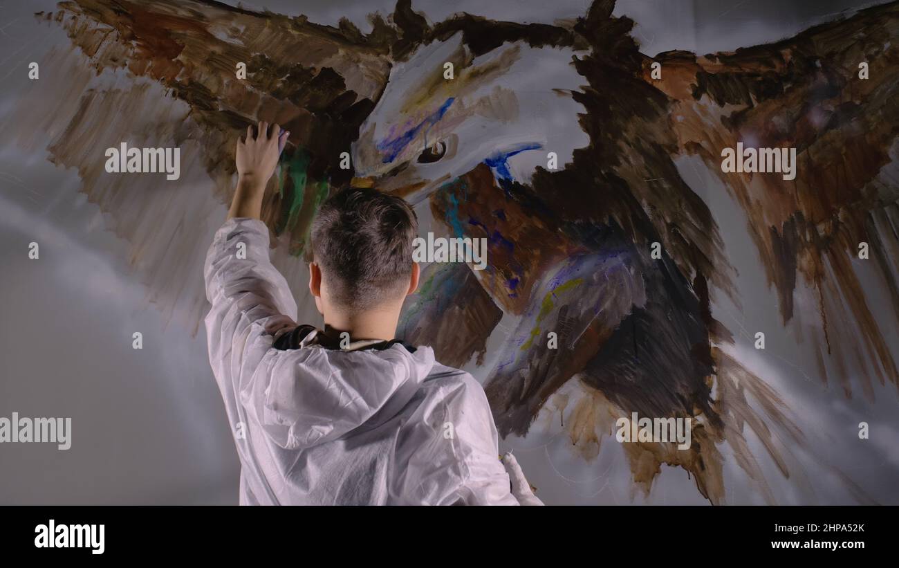Artist designer draws an eagle on the wall. Craftsman decorator paints ...