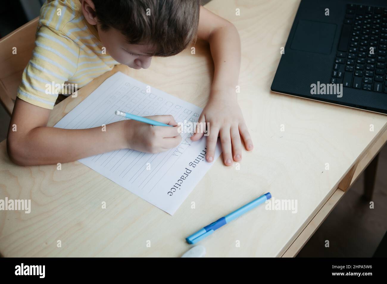 A schoolboy doing math lesson sitting at desk in the children room ...