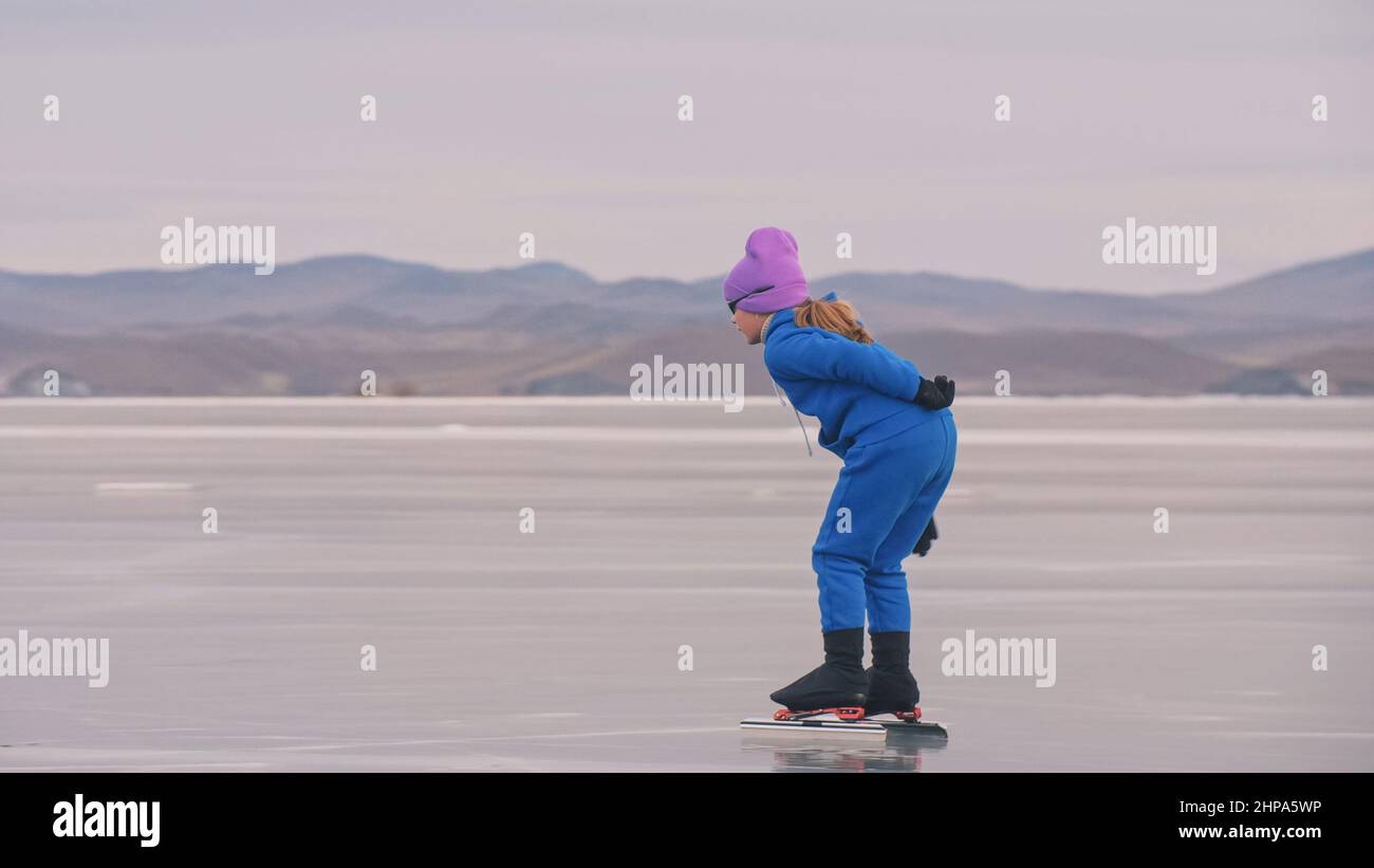 The child train on ice professional speed skating. The girl skates in ...