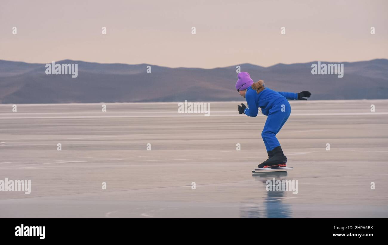 The child train on ice professional speed skating. The girl skates in ...