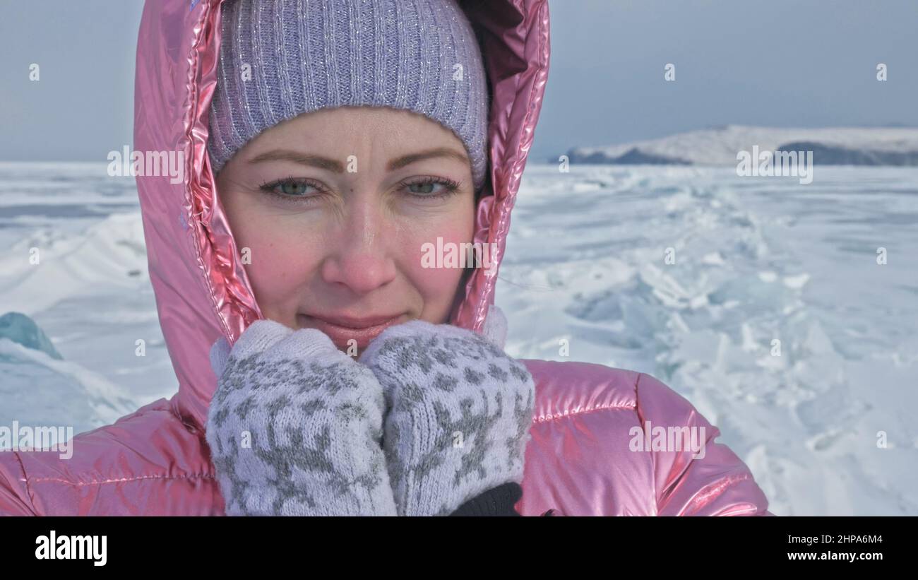 Girl walking on cracked ice of frozen lake Baikal. Woman traveler ...