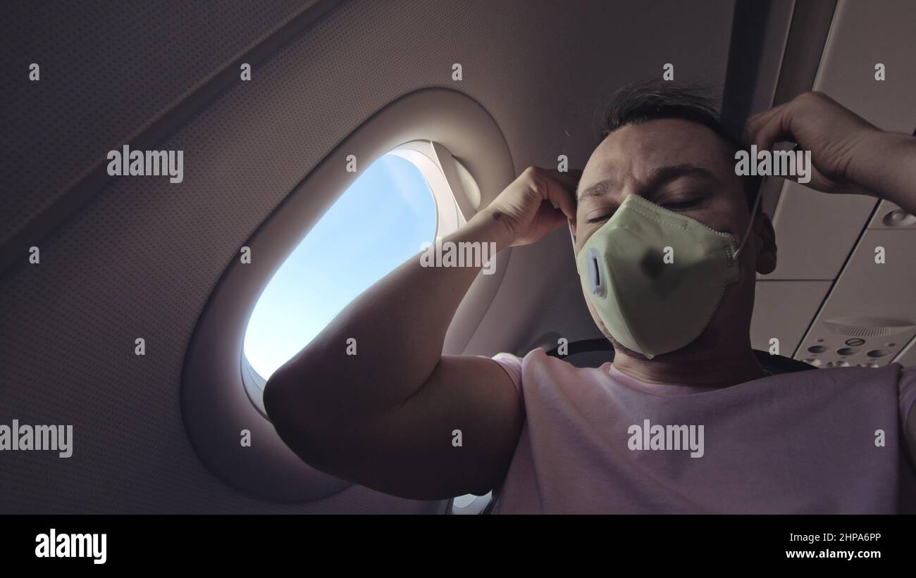 Man travel caucasian at plane with wearing protective medical mask ...