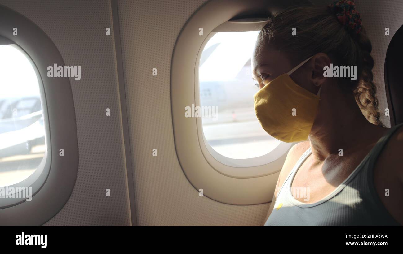 Woman travel caucasian at plane with wearing protective medical mask ...