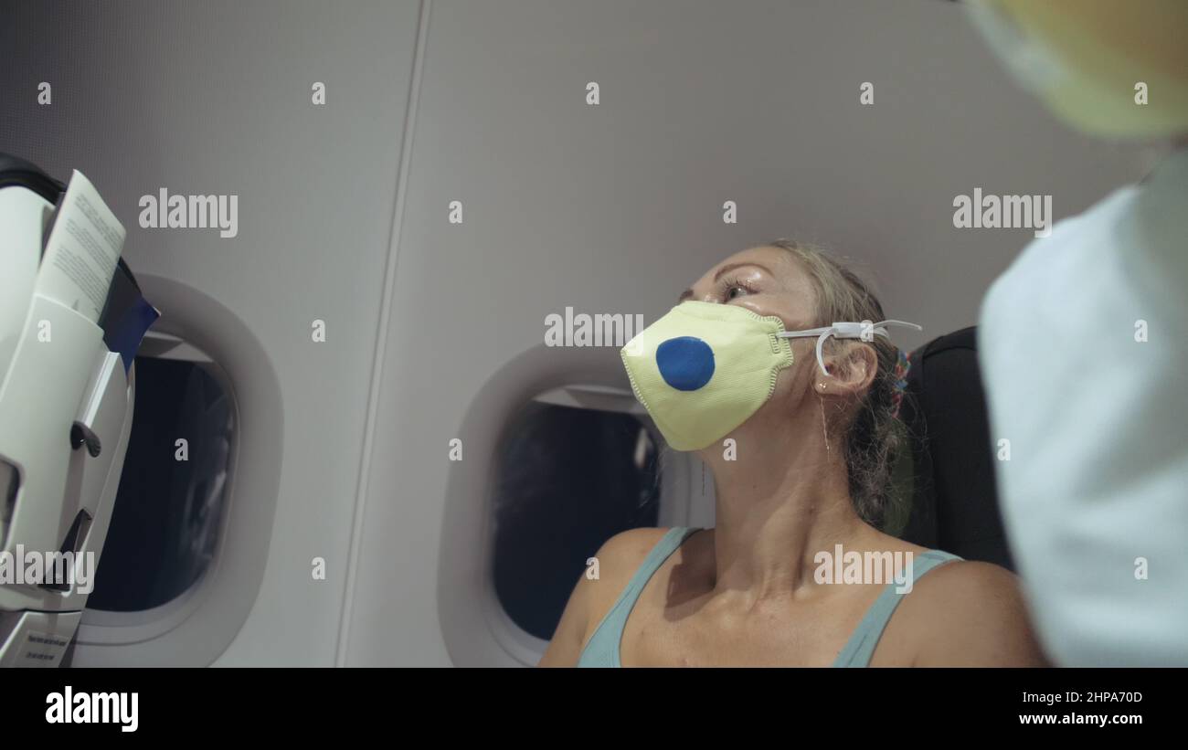 Woman travel caucasian at plane with wearing protective medical mask ...