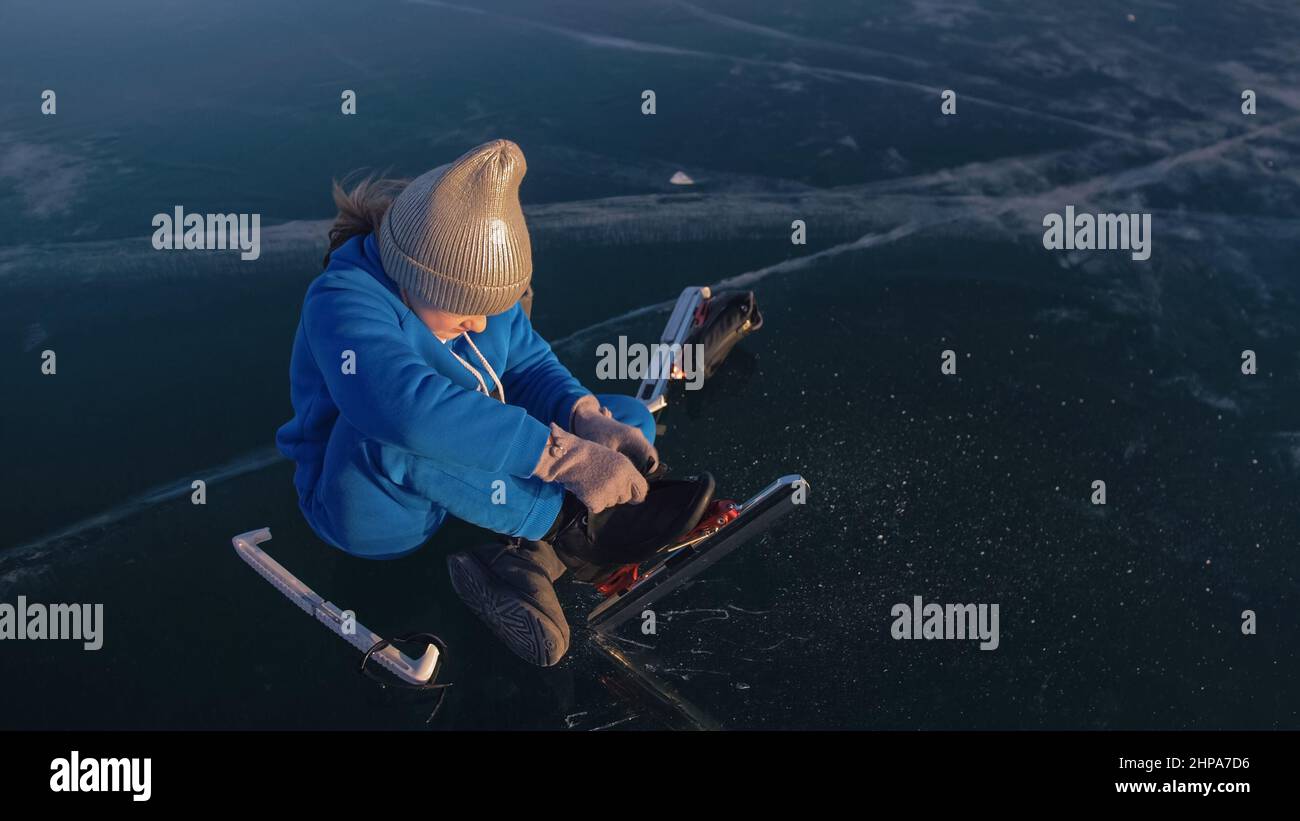 The child train on ice speed skating. Athlete puts on skates. The girl ...