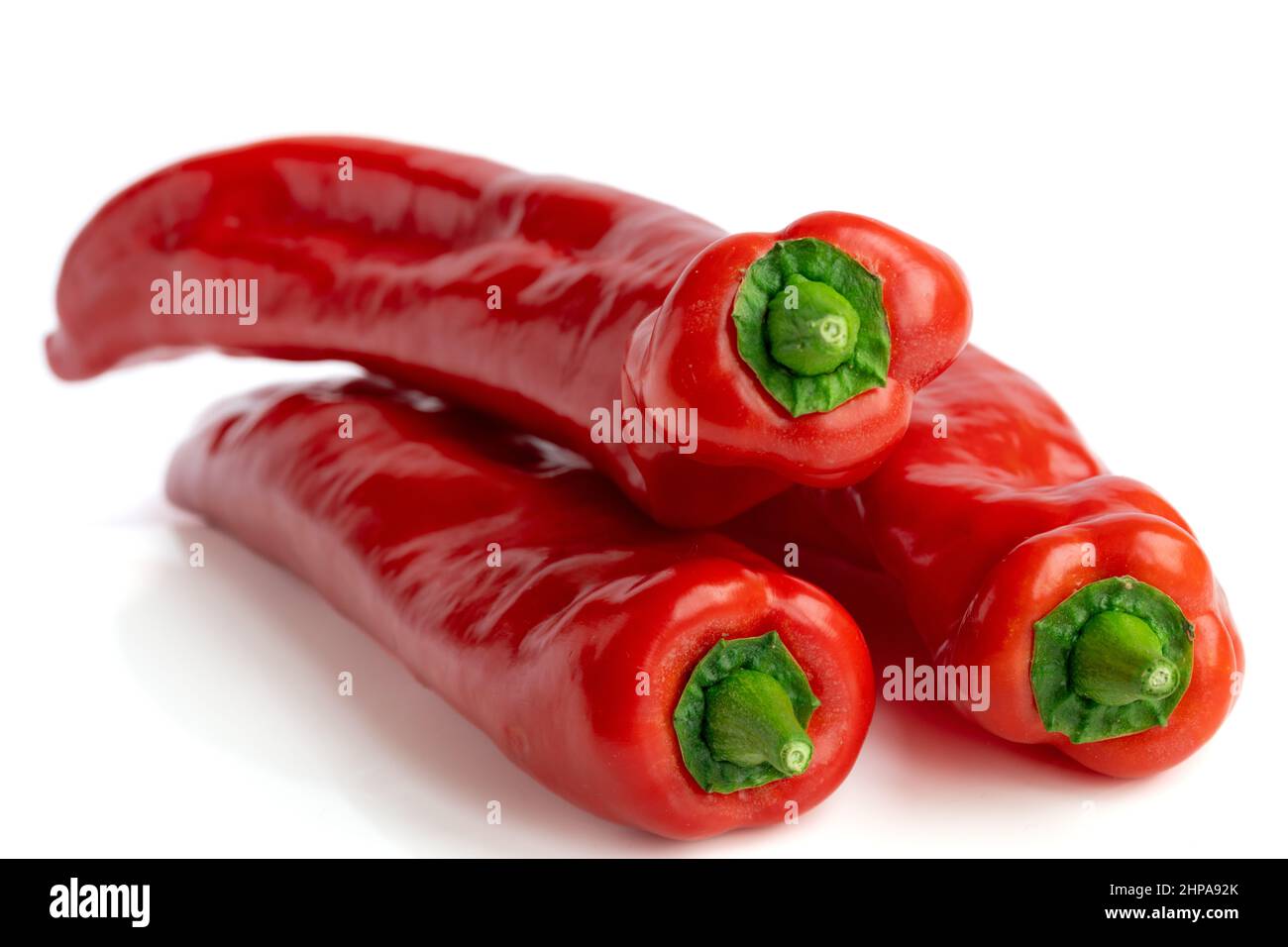 Closeup shot of three red pointed pepper placed on each other isolated ...