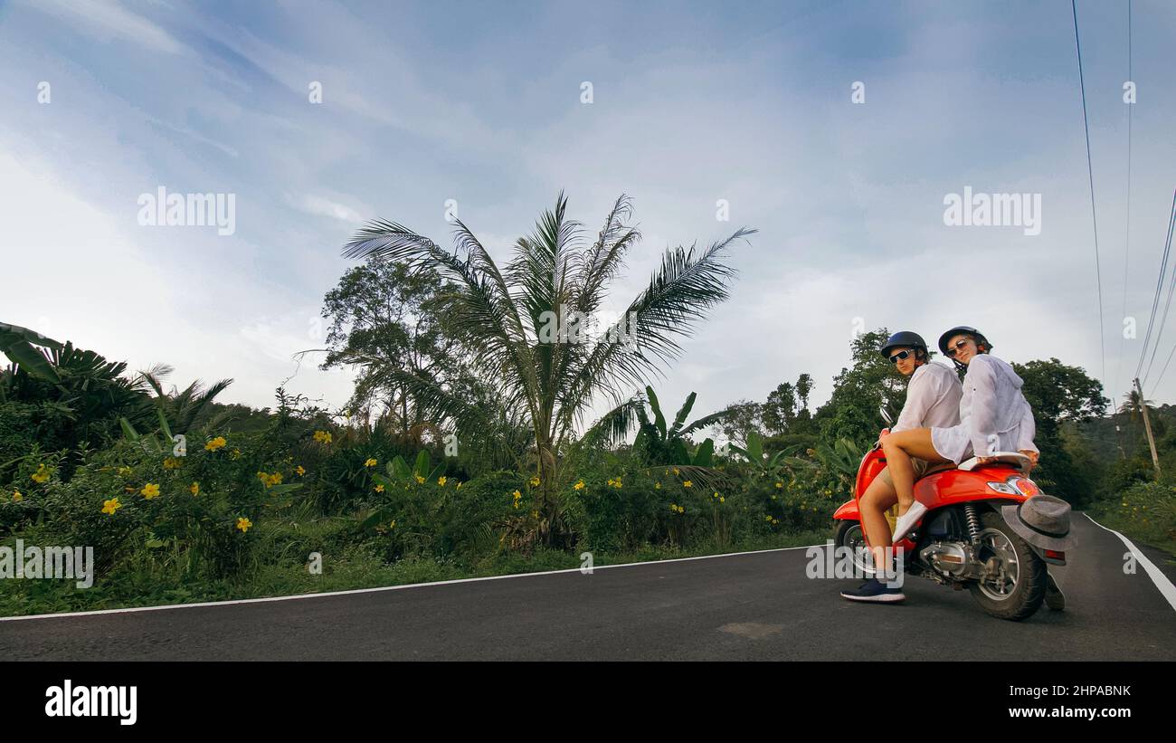 Scooter road trip. Love couple on red motorbike in white clothes on ...